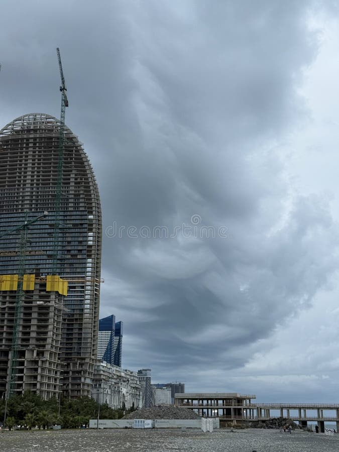 Unfinished High-rise Building with Cranes on a Cloudy Day by the Beach ...