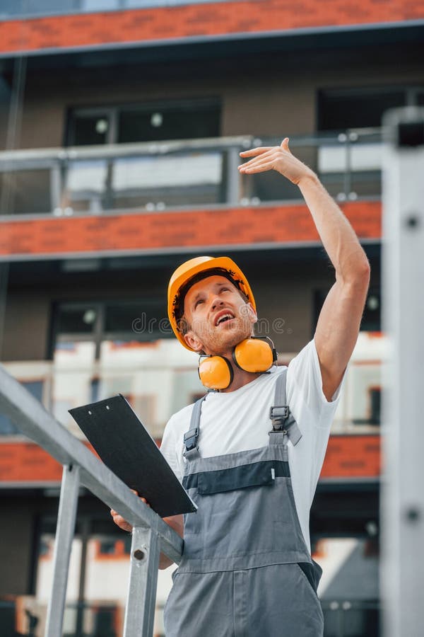 Unfinished Project. Young Man Working in Uniform at Construction at ...