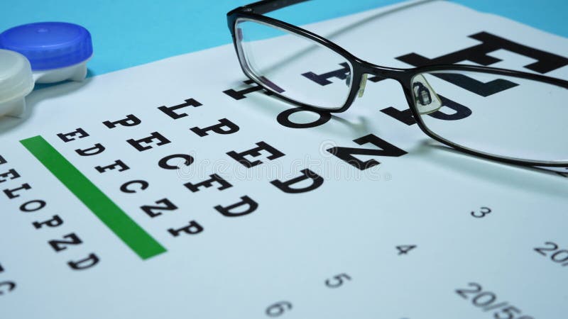 Unfocused Eye Chart on the Table with Glasses and a Container for ...