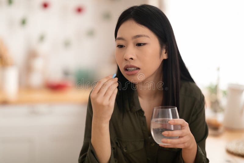 Unhappy Asian Woman Suffering from Pain, Taking Pill Stock Image ... Unhappy Asian Woman Suffering from Pain, Taking Pill Stock Image ...