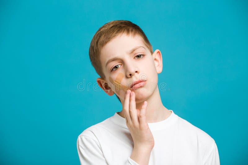 Unhappy Boy in White with Adhesive Plaster on His Cheek Stock Image ...