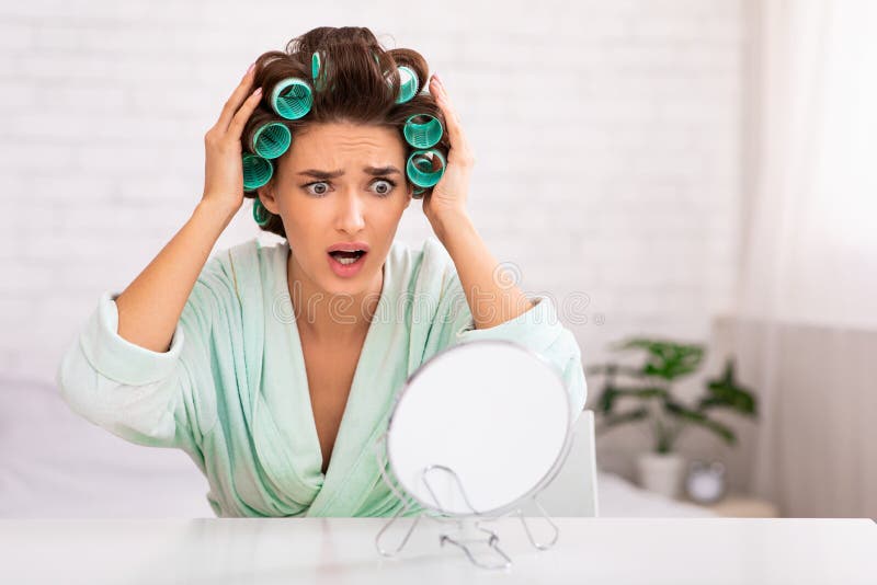 Unhappy Woman Touching Hair Curling It Sitting At Home Stock Image