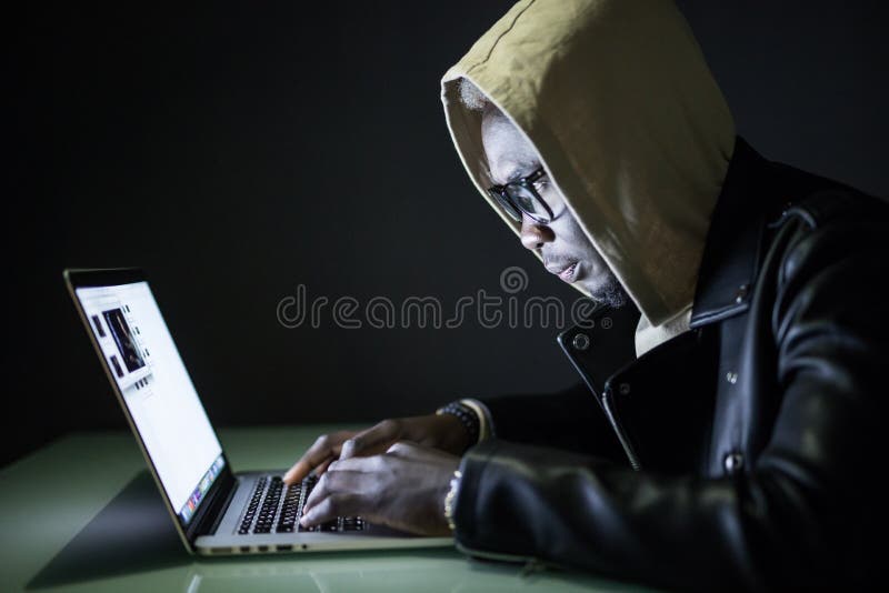 Afro American Hacker in Hood Using Laptop Computer in the Dark Hack ...