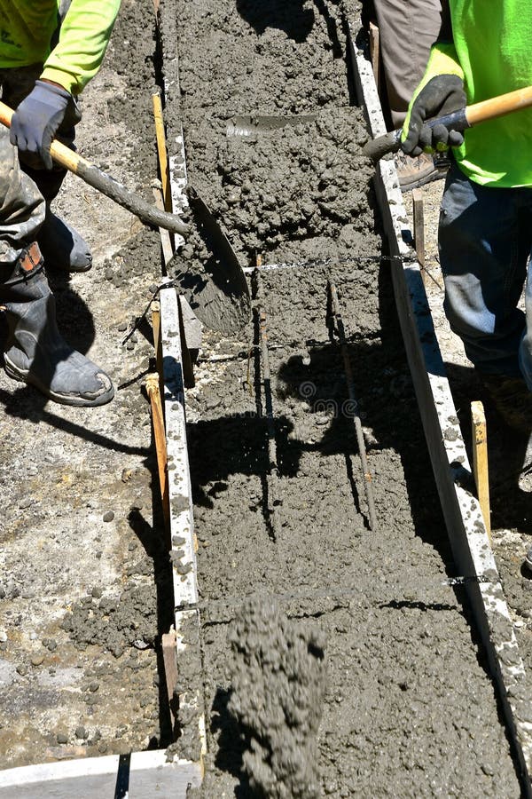 Laborers Moving Wet Concrete on a Building Project As Footings are ...