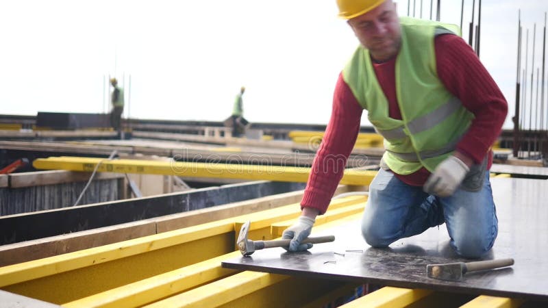 Construction Worker Hammering Nails on a Lively Site Stock Image ...