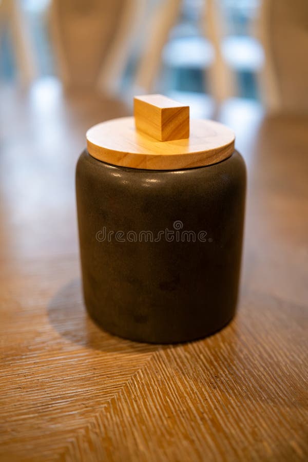 Unique Black Jar with Wooden Lid on a Textured Wooden Table in a Modern ...