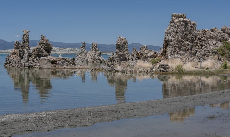 Unique Rock Formations Reflected in Calm Water Under a Clear Blue Sky ...