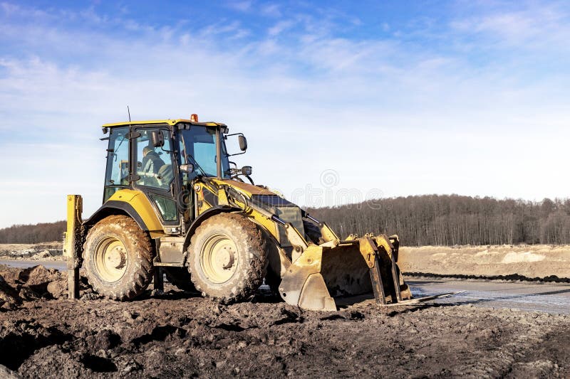 A Universal Excavator or Loader is Working on a Construction Site ...