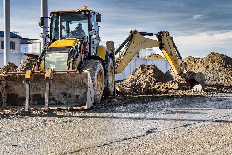 A Universal Excavator or Loader is Working on a Construction Site ...
