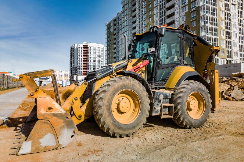 A Universal Excavator or Loader is Working on a Construction Site ...