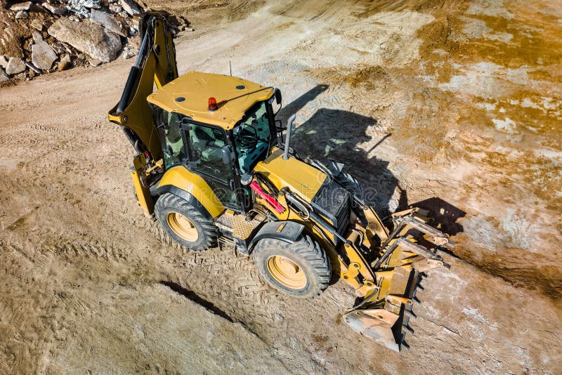 A Universal Excavator or Loader is Working on a Construction Site ...