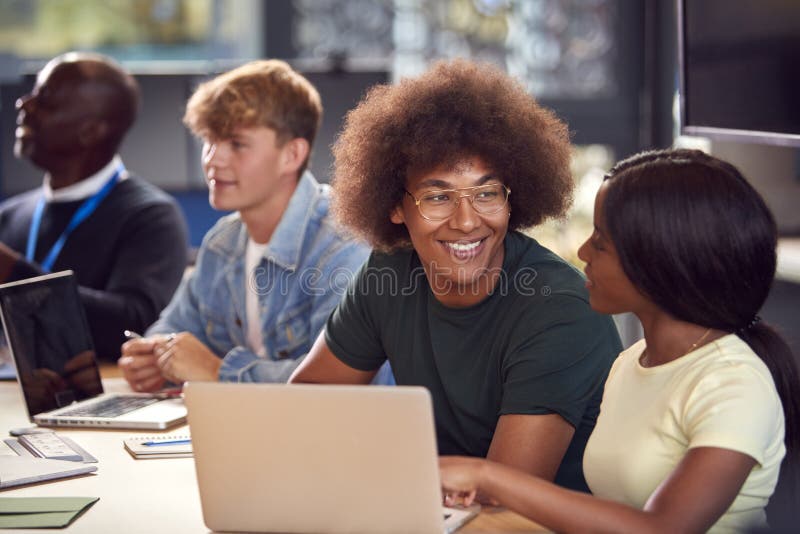 University or College Students Sitting Around Table with Tutor ...