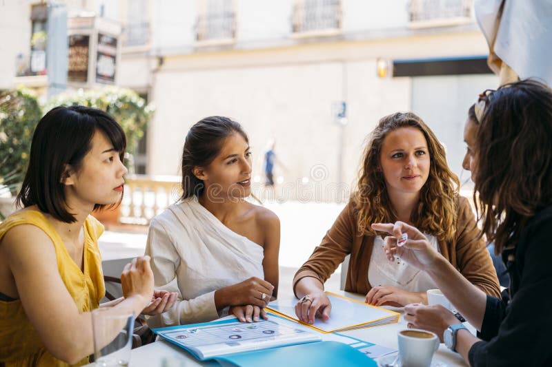 University Exchange Students Discussing Project at Outdoor Cafe Stock ...