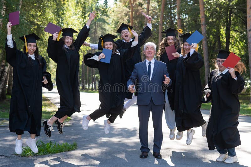 A University Professor and Seven Robed Graduates are Jumping Outdoors ...