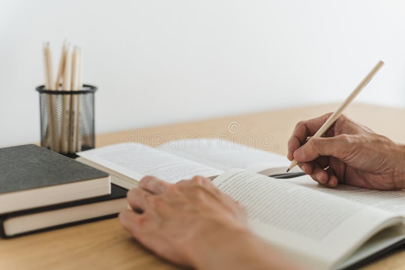 University Student Studying, Writing and Reading Book or Textbook ...