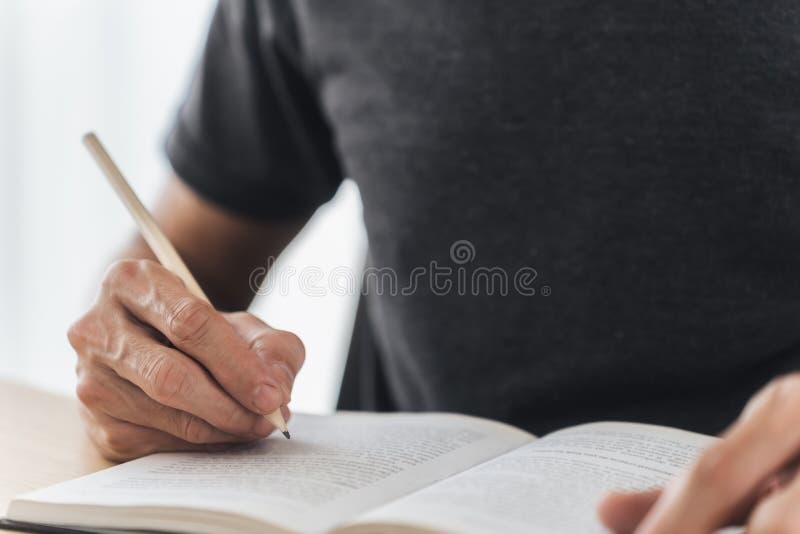 University Student Studying, Writing and Reading Book or Textbook ...