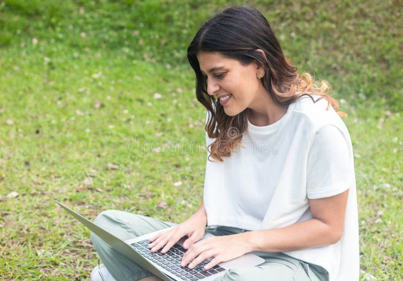 University Student Using Laptop Outside Sitting on the Grass Stock ...