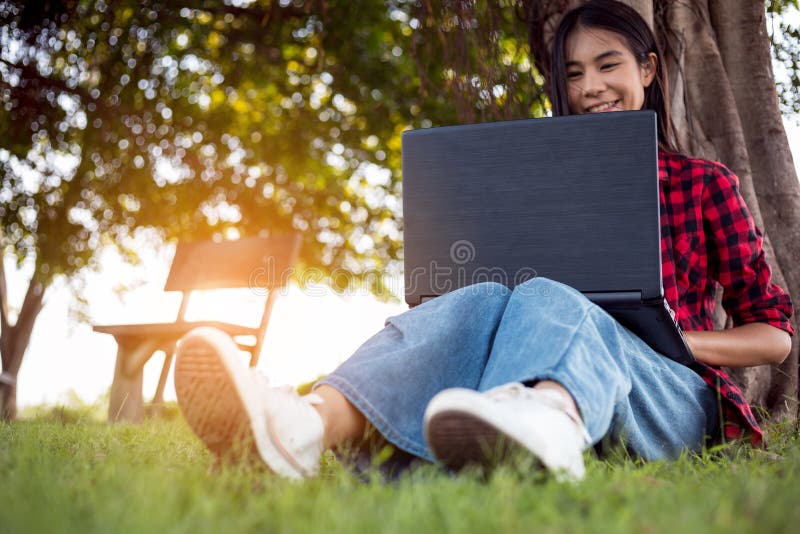 University Student Using Laptop Under Tree for Studying. Education ...