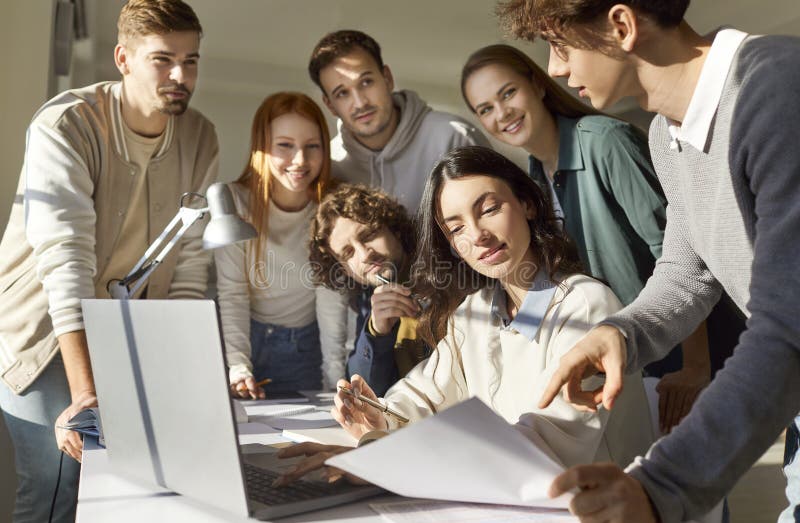 University Students Gathered Around Desk Discussing Project and Sharing ...