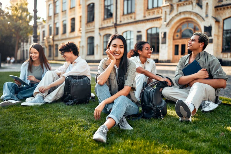 University Students Relax on the Green Grass on the Campus. Stock Photo ...