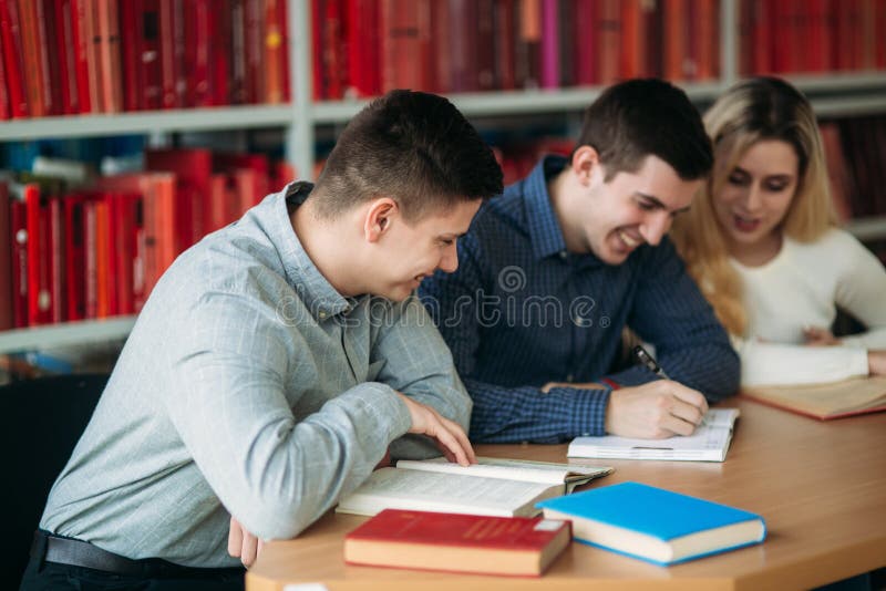 University Students Sitting Together at Table with Books and Laptop ...