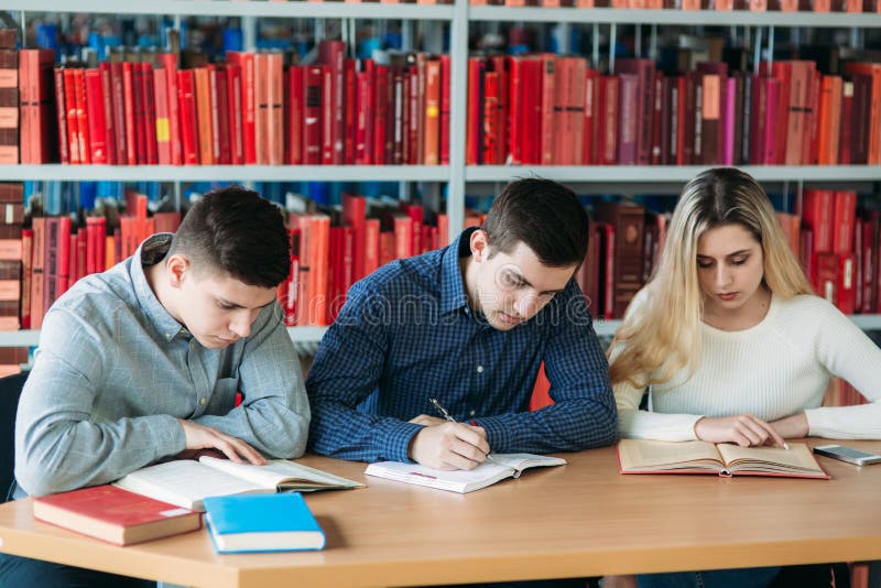 University Students Sitting Together at Table with Books and Laptop ...