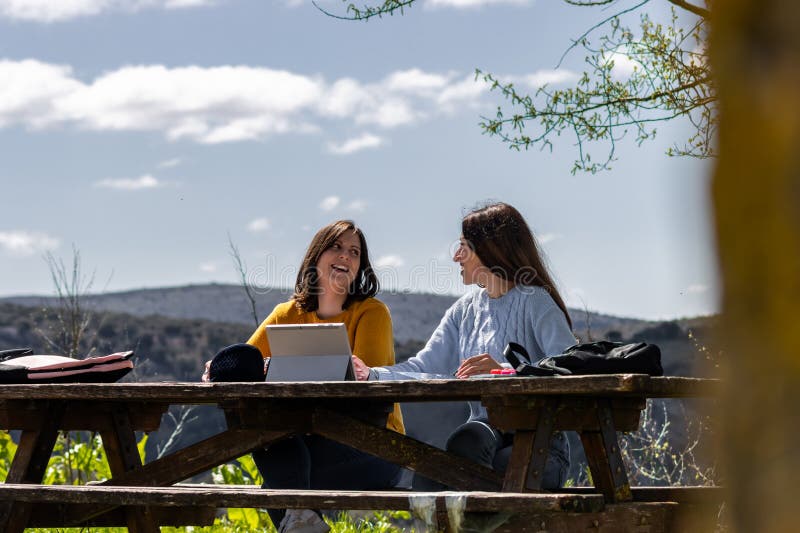 University Students Studying Outdoors with Tablet and Discussing ...
