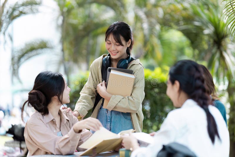 University Students Studying Outdoors on Campus with Laptop and Book ...