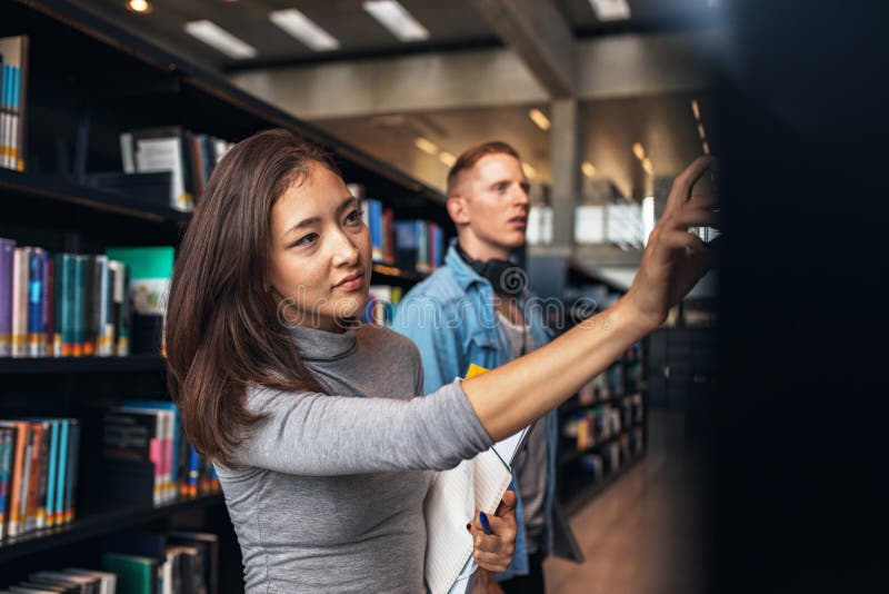University Students Taking Book from Shelf in Library Stock Photo ...