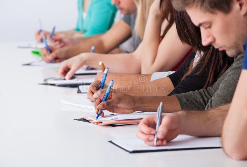 University Students Writing at Desk Stock Photo - Image of hispanic ...