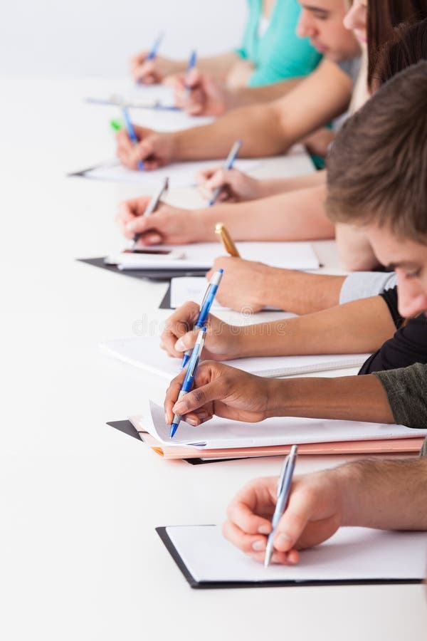 University Students Writing at Desk Stock Image - Image of desk, girl ...