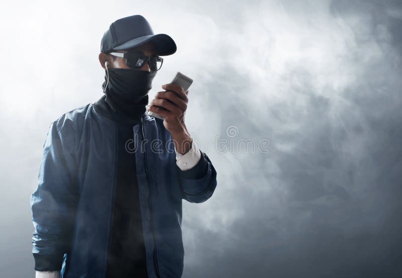Unknown Hacker in the Hood with a Laptop in His Hand on a Background of ...