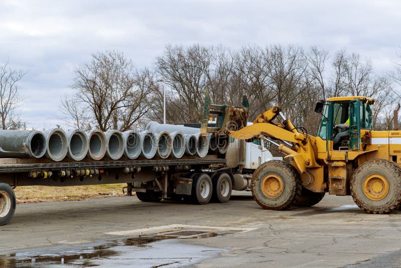 Unloading Concrete Sewer Pipes Stock Photo - Image of bulldozer ...