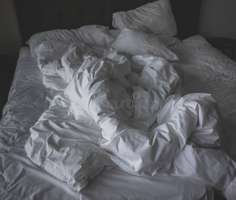 Unmade bed at a hotel.. stock photo. Image of comforter - 369745716