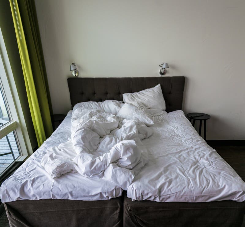 Unmade bed at a hotel.. stock image. Image of lamp, armchair - 354847067