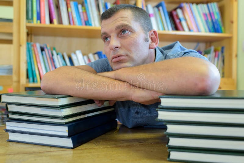 Unmotivated Man Leaning on Two Stacks Books in Library Stock Photo ...