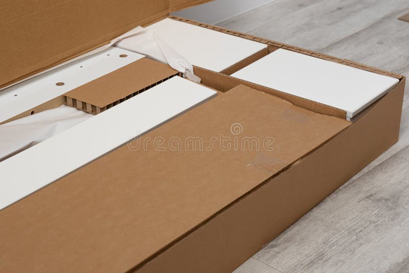 Unpacking a Cardboard Box with Furniture. Assembling Furniture Concept ...