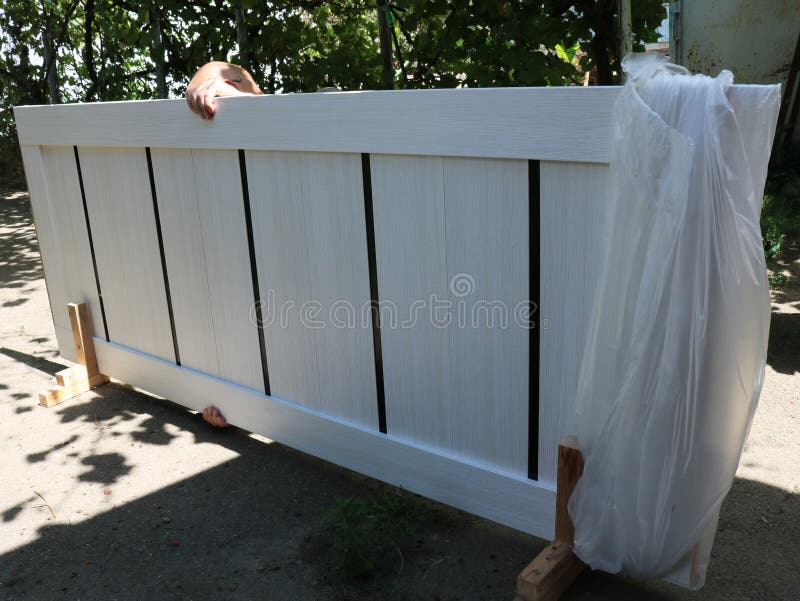 Unpacking a Light Polyethylene Door Leaf Using Stands in the Courtyard ...