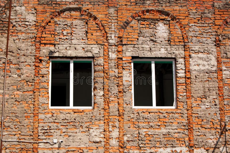 Unplastered Brick Wall of a Building with Two Windows Stock Photo ...