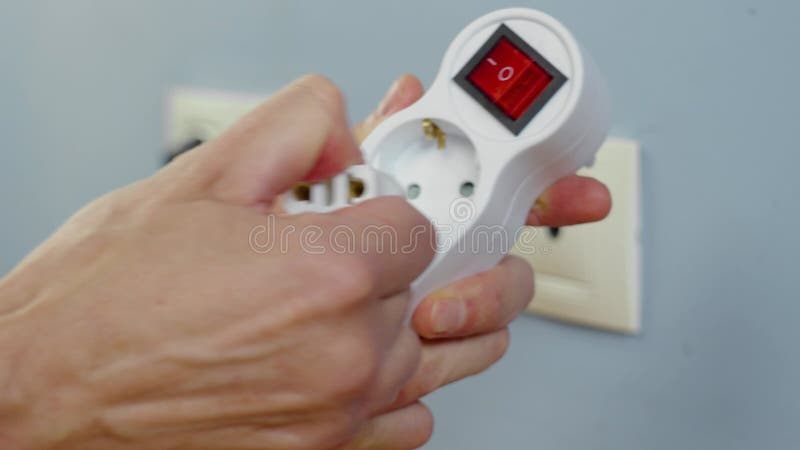 Unplugging an Electrical Power Cord from a Wall Socket in the Office ...