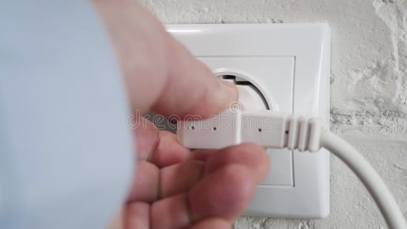 Unplugging an Electrical Power Cord from a Wall Socket in the Office ...