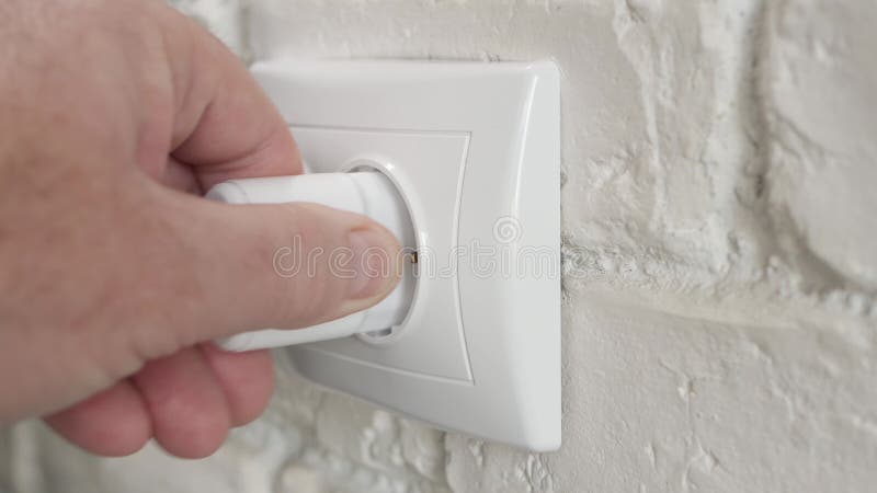 Unplugging an Electrical Power Cord from a Wall Socket in the Office ...