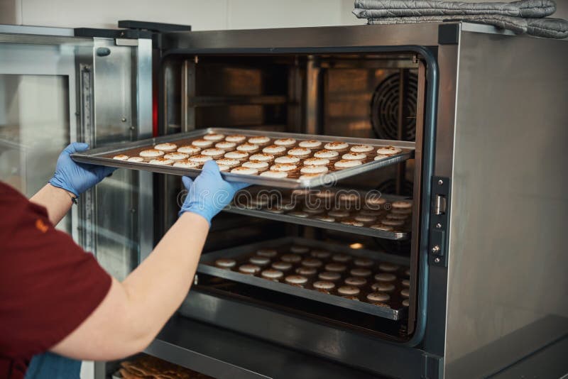 Unrecognised Cook Baking a Batch of Macarons in the Oven Stock Photo ...