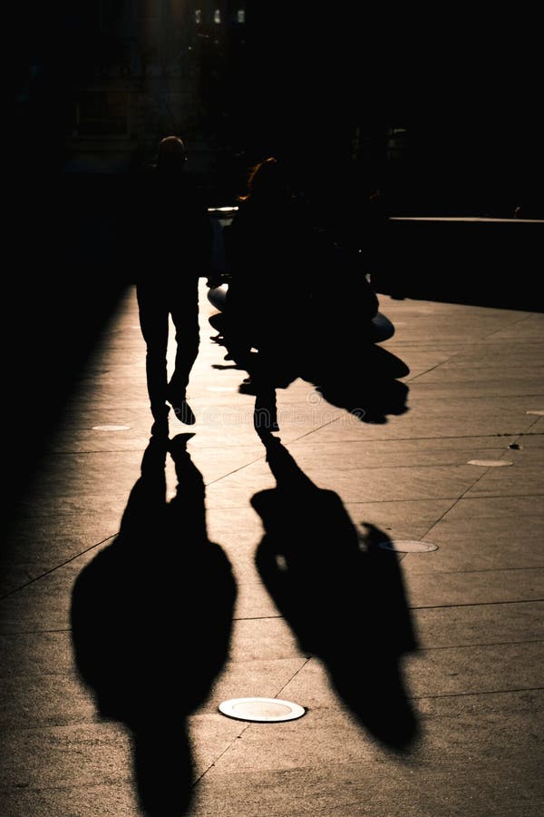 Unrecognised People Walking with Backlight Creating Strong Shadows and ...