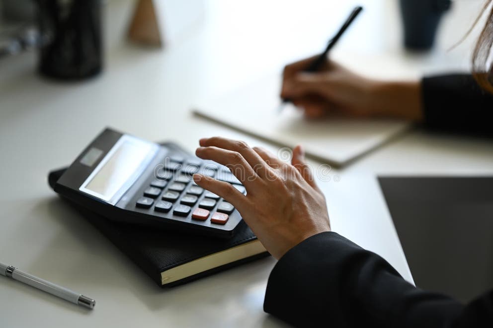 Unrecognizable Female Accountant Using Calculator and Making Notes in ...