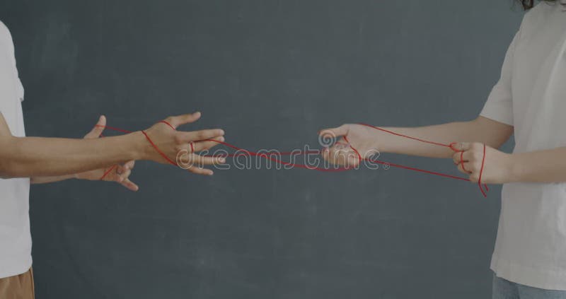 Unrecognizable Girl and Guy Pulling Strings Wrapped Around Hands ...