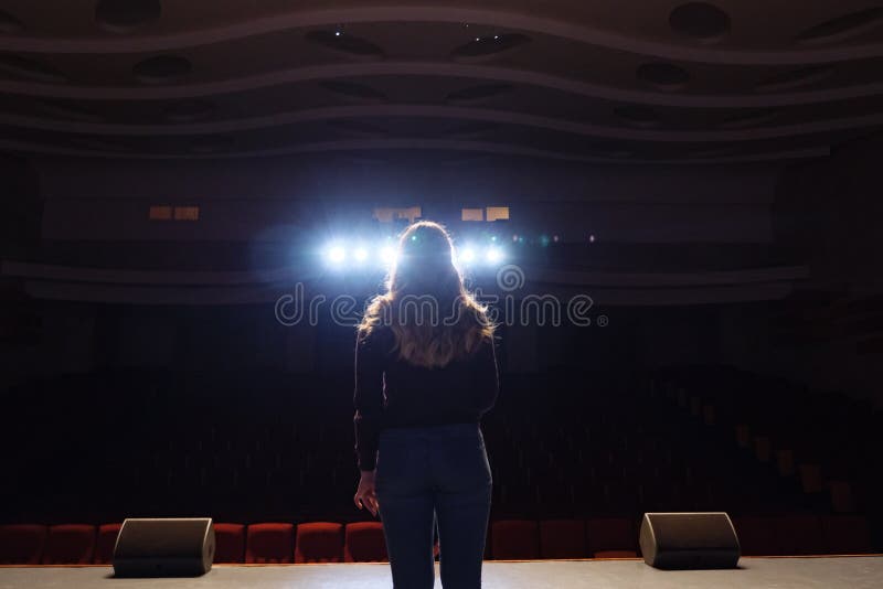 The Unrecognizable Girl Singing on the Stage in Front of the Spotlight ...