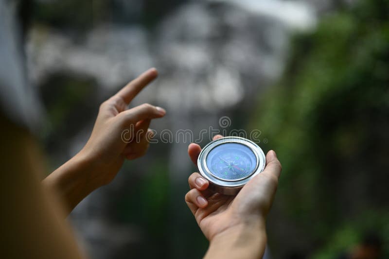 Unrecognizable Male Hiker Using Compass For Directions While Exploring Nature In The Forest