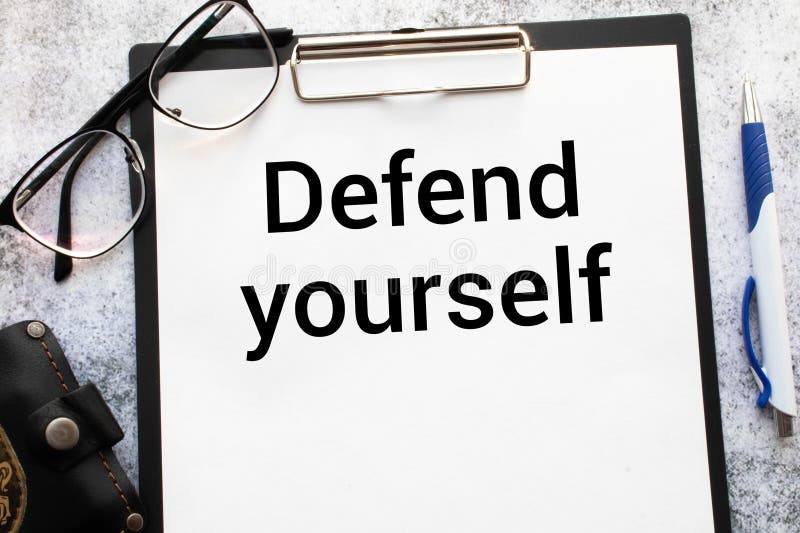 Unrecognizable Man Holding a Card on Which is Written Defend Yourself ... Unrecognizable Man Holding a Card on Which is Written Defend Yourself ...