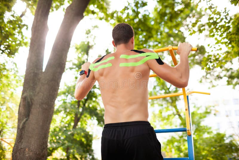 Unrecognizable Man Pulling Up with Kinesiological Taping Outdoors ...